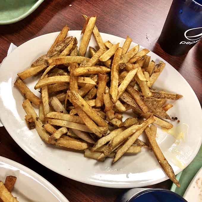 Golden, crispy fries piled high like edible treasure, because every great gyro deserves an equally great supporting cast.