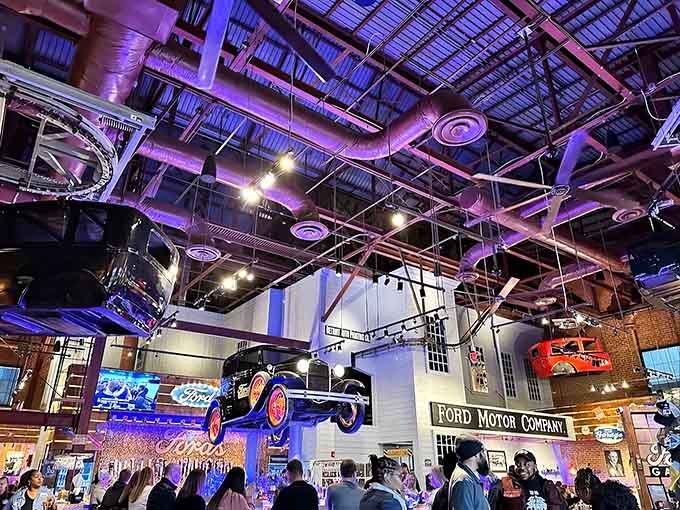 Exposed ductwork glows with purple lighting while vintage vehicles float overhead, creating an industrial wonderland that's pure Instagram gold.