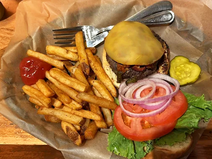The burger arrives like a beautiful meat monument, complete with all the fixings and a side of golden fries that crunch just right.