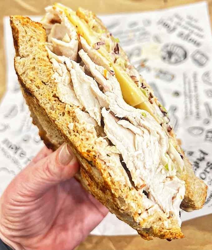 The Georgia Reuben proves turkey can transcend its bland reputation when paired with coleslaw, Swiss cheese, and Russian dressing on perfectly grilled rye bread.