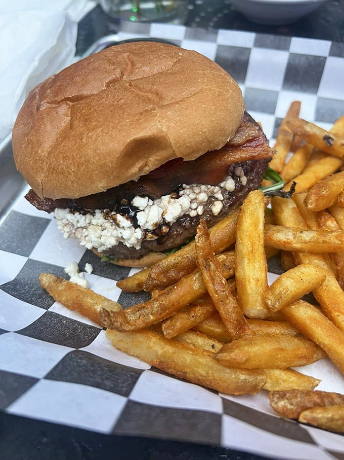 This goat cheese burger balances tangy creaminess with savory beef, while the fries stand at attention, golden soldiers ready for dipping duty.