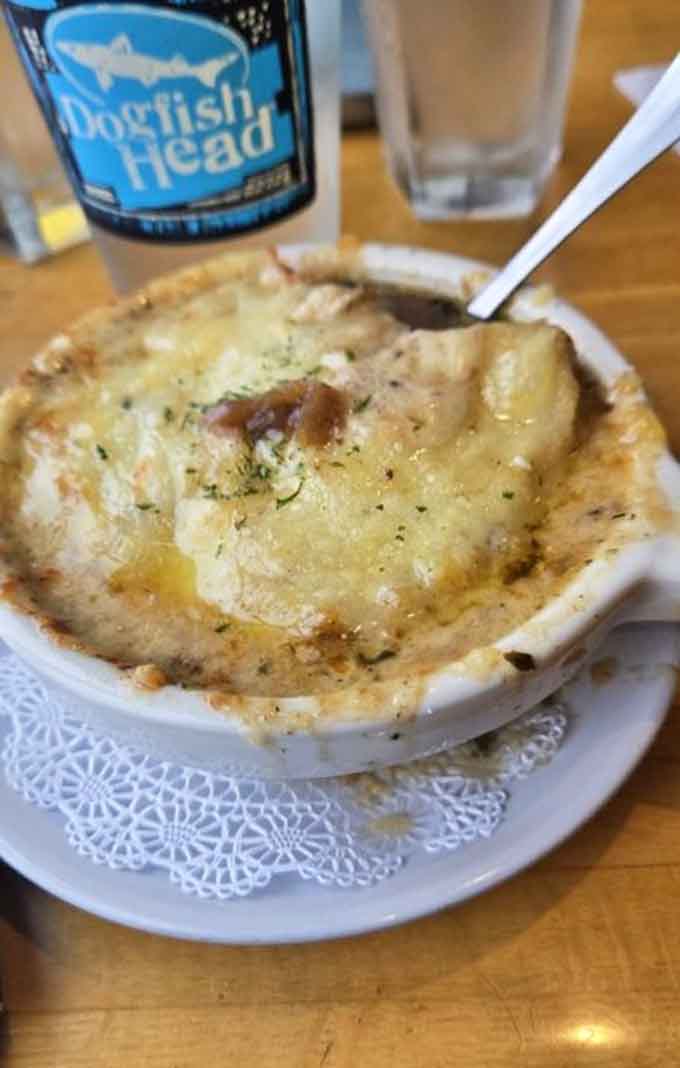 French onion soup arrives bubbling under a golden cheese blanket, ready to warm you from the inside out.