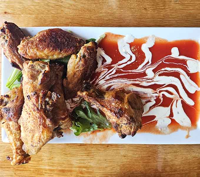 Perfectly seasoned chicken arrives with artistic sauce drizzles that show someone in that kitchen really cares about presentation.