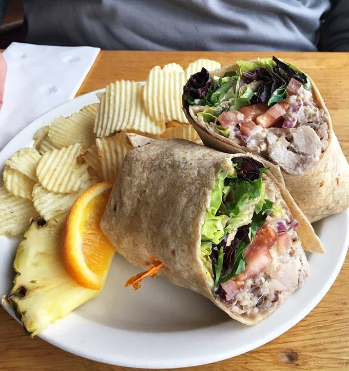 The Waldorf chicken wrap arrives with waffle-cut chips and fresh fruit, turning a simple sandwich into something worth writing home about.