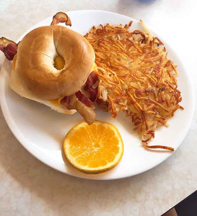A bagel sandwich with hash browns on the side, because sometimes you need carbs with your carbs and that's okay.