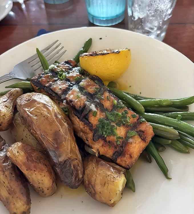 Grilled salmon with roasted potatoes and crisp green beans proves the kitchen knows its way around non-crustacean seafood with equal skill and care.