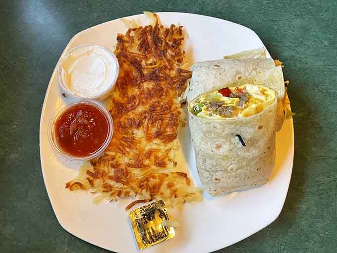 The Breakfast Burrito sits plump and proud next to a mountain of crispy hash browns, proving breakfast is indeed the most important meal.