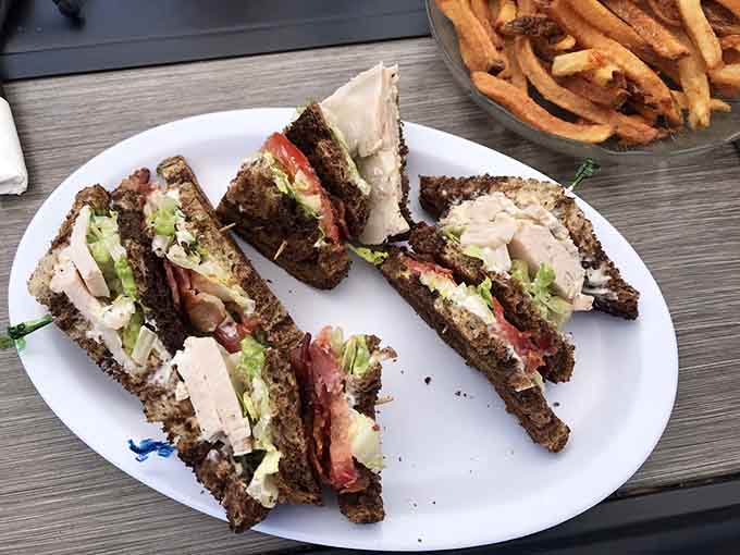 The club sandwich stacked high enough to require architectural planning, because sometimes more really is more.