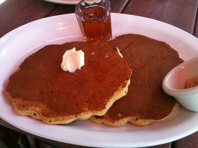 Pancakes so fluffy they practically hover above the plate, with real maple syrup standing by for its supporting role in breakfast perfection.