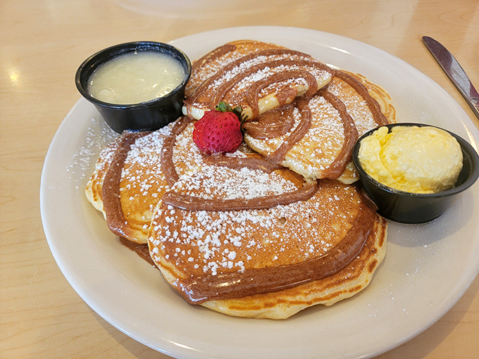 Pancakes so fluffy they practically hover above the plate, drizzled with syrup that catches the light like liquid amber.