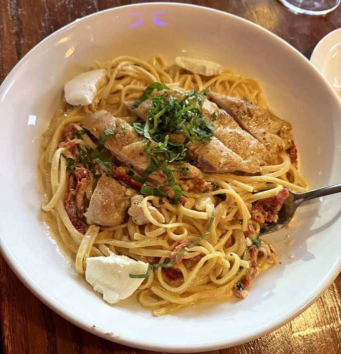 Pasta Vinaio showcases the kitchen's versatility – tender chicken breast over linguine in a creamy lemon sauce that'll make you forget you're in a burger joint.