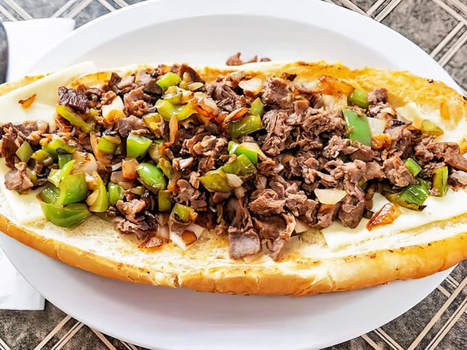 Thinly sliced beef mingles with saut&eacute;ed peppers and onions under a blanket of melted cheese &ndash; Philly perfection on a Michigan plate.
