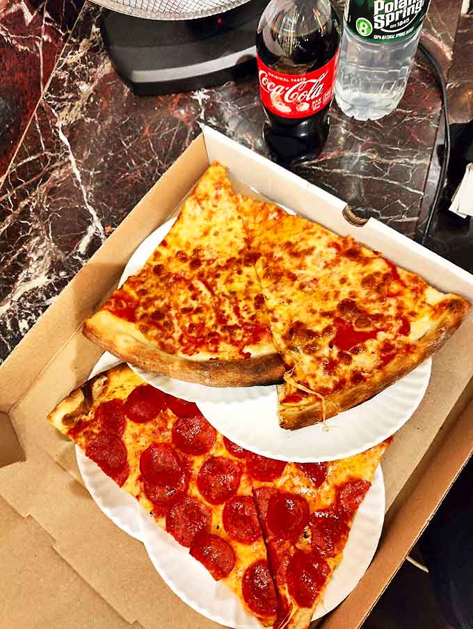 The classic pairing: a perfectly simple cheese slice alongside a cold Coca-Cola &ndash; sometimes the most basic pleasures are life's greatest luxuries.