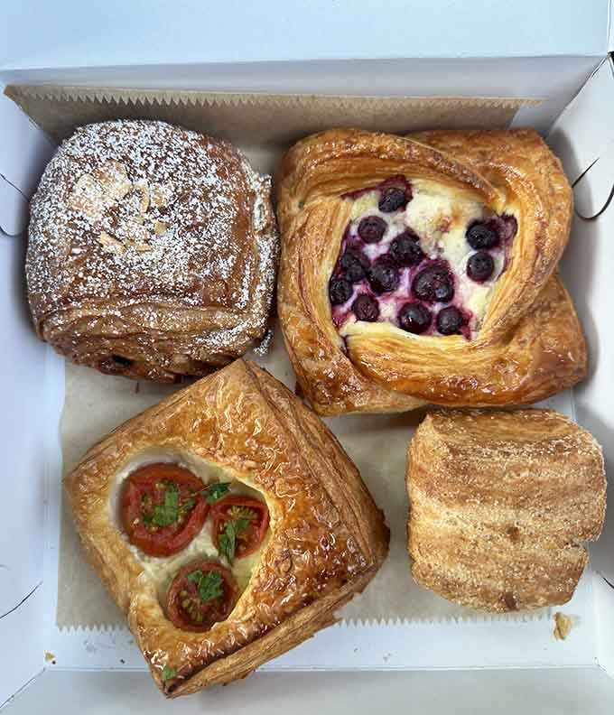 A pastry box filled with Danish delights and flaky treats that look like they graduated top of their class from pastry school.