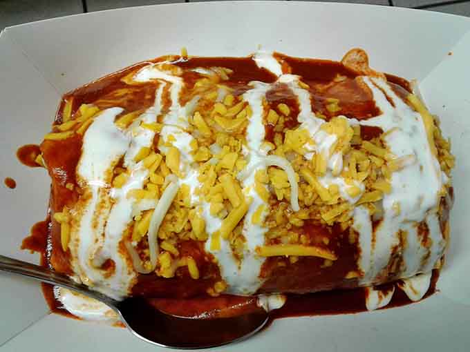 This burrito is dressed to impress, drizzled with sauce and cheese like edible artwork you almost hate to disturb.