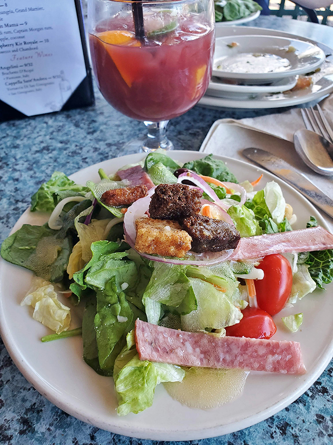 A vibrant salad provides the perfect counterpoint to rich pasta dishes, with fresh greens, colorful vegetables, and house-made dressing.