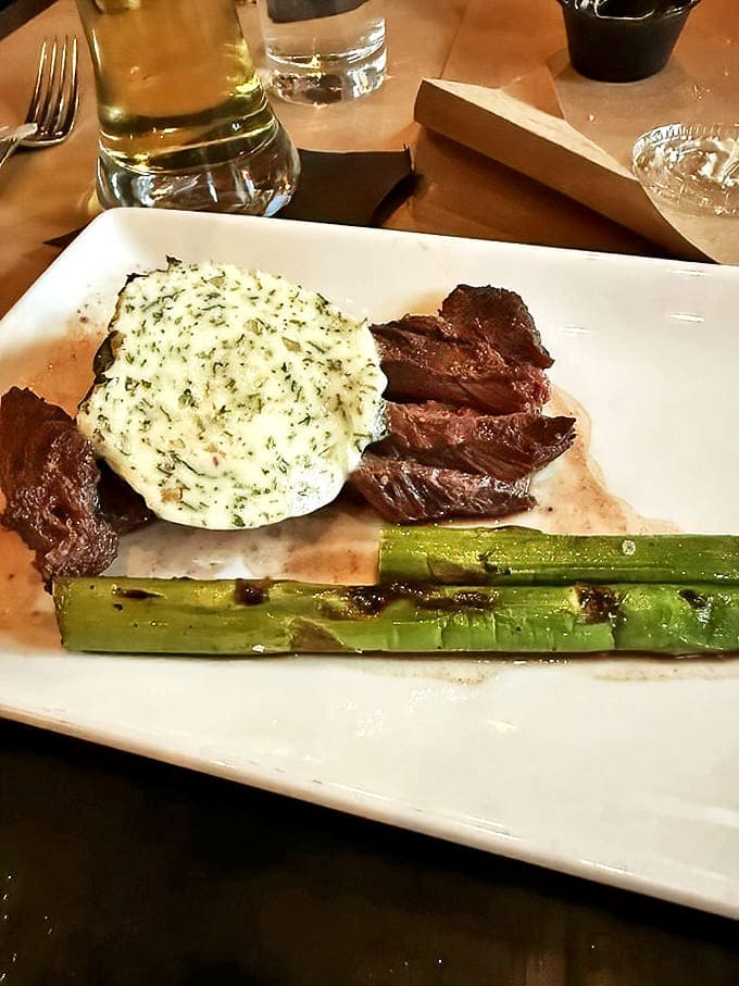 Hanger steak cooked to pink perfection, topped with herb butter that slowly melts into a sauce worth sopping up with every last fry.