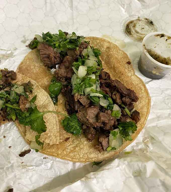 Perfectly grilled steak nestled in a corn tortilla with fresh toppings, simple perfection on a plate.