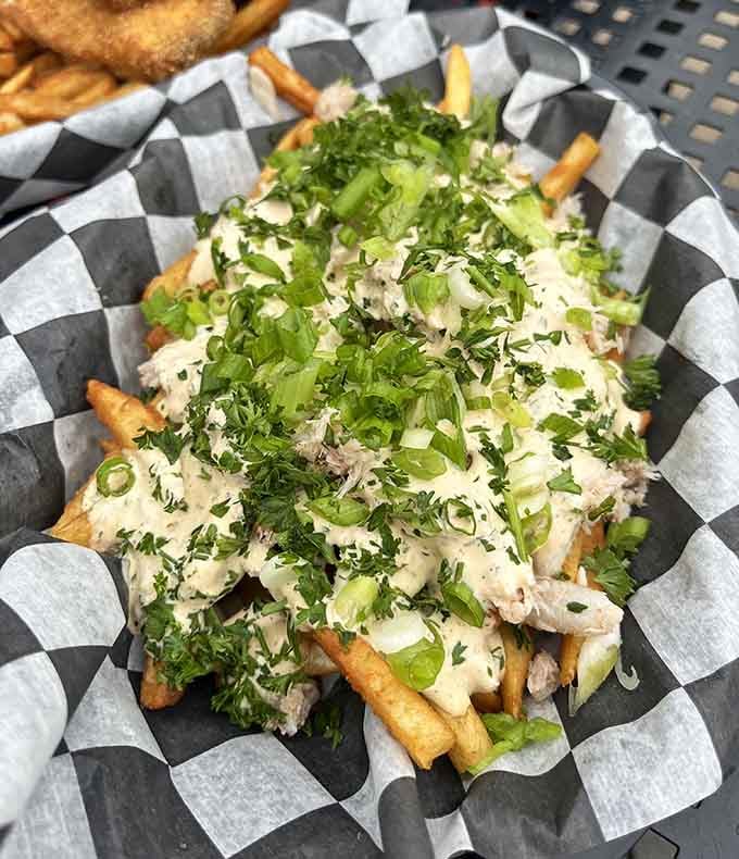 Loaded crab fries topped with cheese and fresh herbs transform a simple side into an indulgent masterpiece worth every calorie.