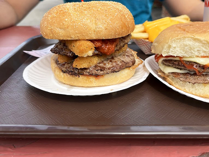 A towering achievement of beef, cheese, and toppings that requires strategy, multiple napkins, and possibly a post-consumption nap.