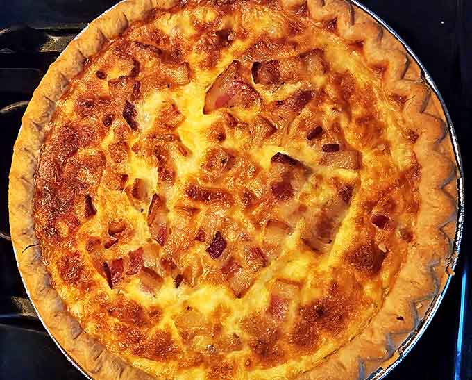 This freshly baked quiche showcases the kitchen's mastery &ndash; a flaky, butter-rich crust cradling a savory filling that's pure comfort.