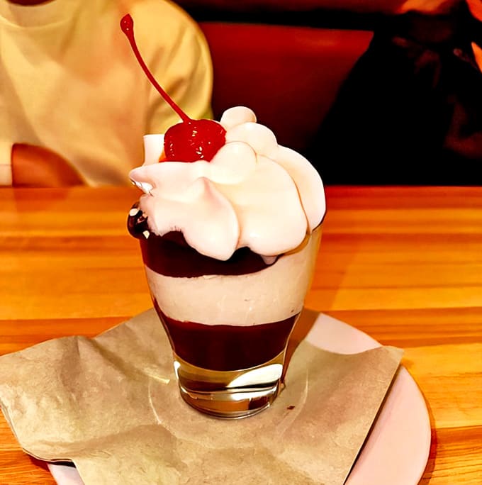 Hot fudge sundae: A towering finale of vanilla ice cream, hot fudge, and whipped cream that brings childhood joy to the grown-up table.