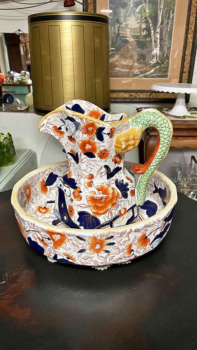 This exquisite Japanese-inspired pitcher and basin set features intricate floral designs and that distinctive serpentine handle that collectors dream of finding.