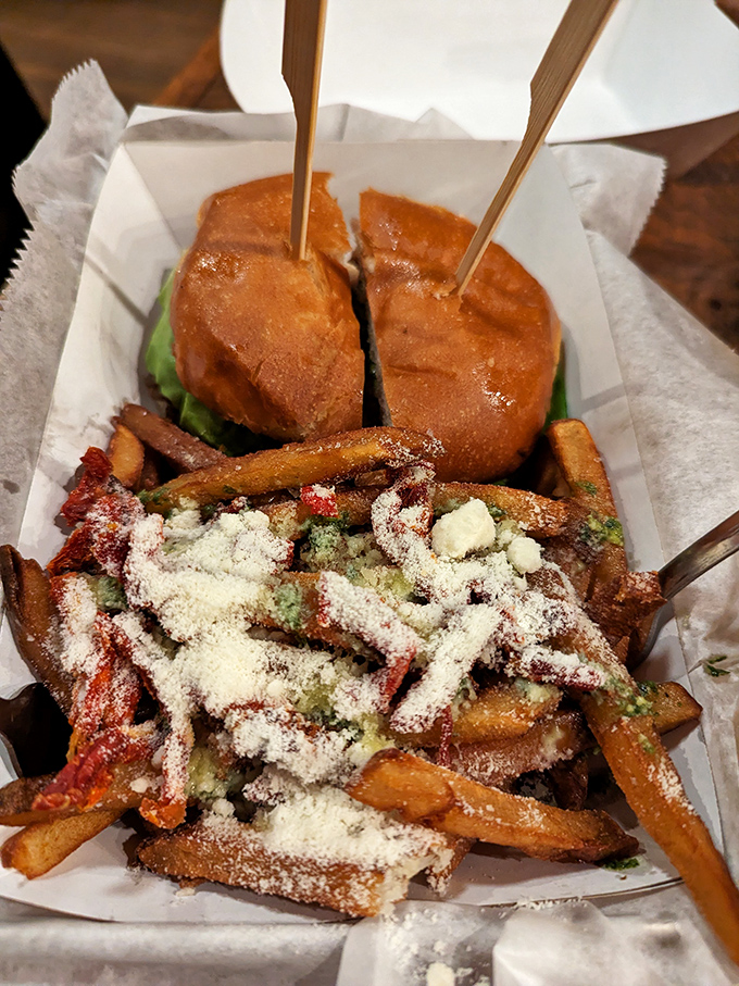 A burger split to reveal its perfectly cooked interior, surrounded by those legendary truffle fries that have developed their own cult following throughout New England.