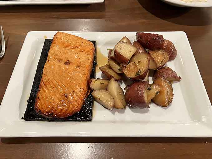 Cedar plank salmon with roasted potatoes shows this kitchen's range extends well beyond beef, delivering seafood with equal finesse.