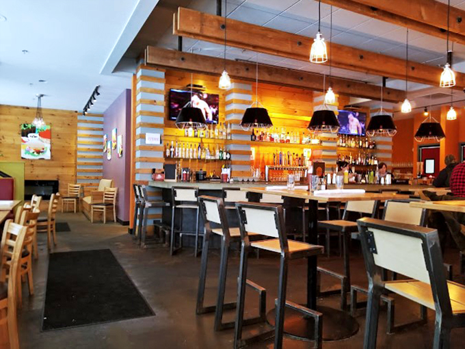 Industrial pendant lights cast a warm glow over natural wood walls, creating the perfect setting for everything from casual lunches to date nights.