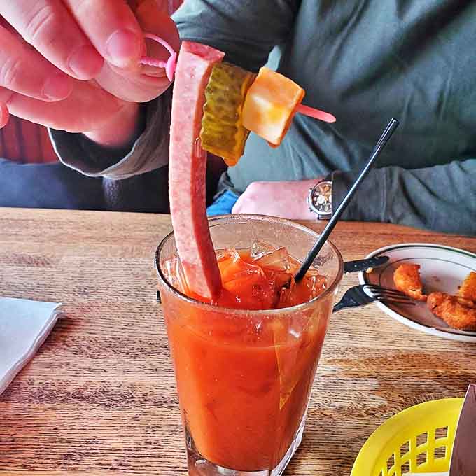 The Bloody Mary arrives like a meal disguised as a cocktail, with its skewer of snacks performing a high-wire act above the spicy tomato base.