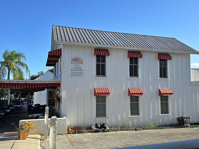 Caf&eacute; Gianni's charming courtyard entrance beckons through a white archway, promising culinary delights in an atmosphere of Mediterranean romance.