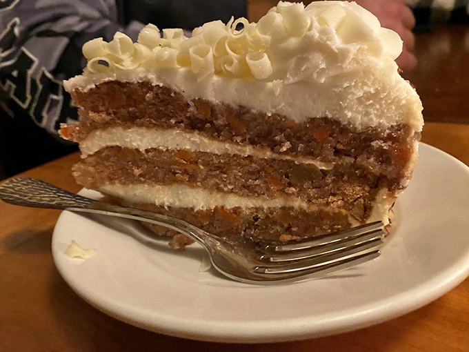 Bernie's carrot cake stands three layers tall, a monument to moist, spiced perfection crowned with cream cheese frosting that's applied with a generous, loving hand.