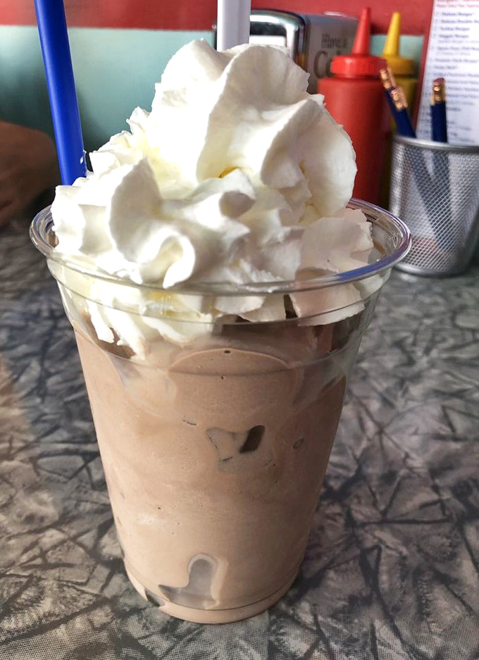 A mountain of whipped cream crowns this velvety chocolate dream &ndash; childhood in a glass.