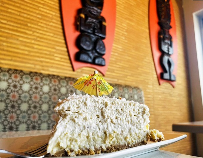 A slice of coconut cream pie so light and airy it practically floats off the plate, crowned with a tiny umbrella for that perfect vacation vibe.