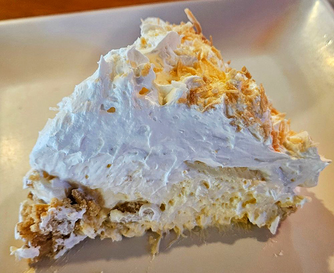 Cloud-like coconut cream pie with a mountain of whipped topping that makes you wonder if dessert should actually be your main course next time.
