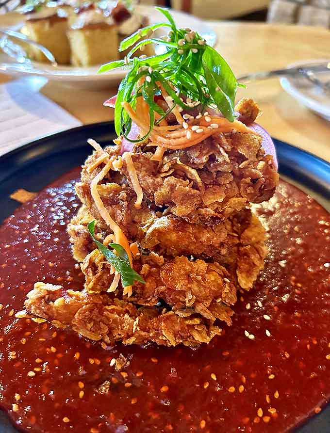 Cornflake-crusted chicken that shatters with each bite, nestled in vibrant sauce with pickled carrots. Comfort food with a PhD.