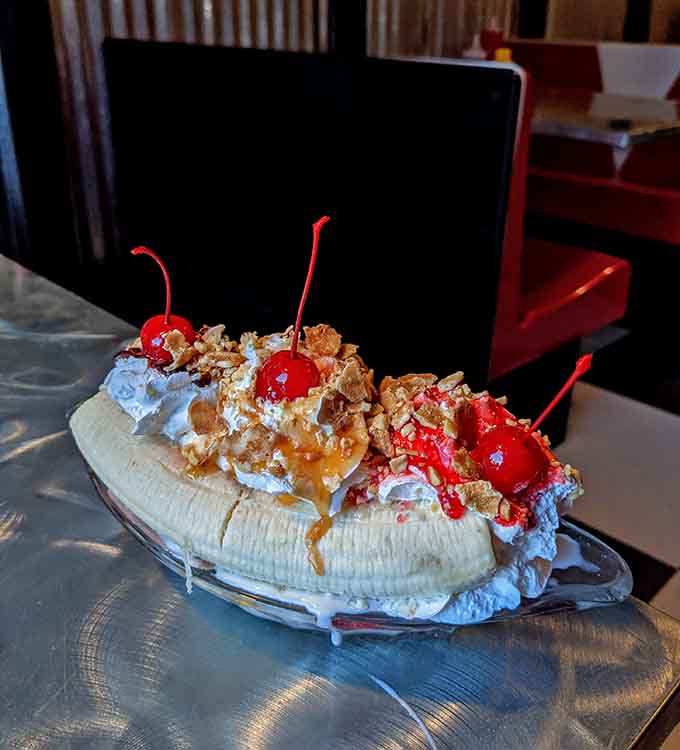 This banana split is an engineering marvel that would make any 1950s soda jerk proud of their whipped cream artistry.