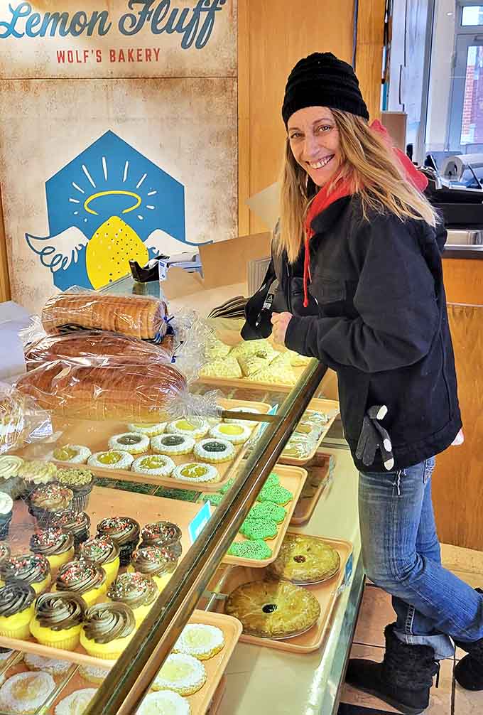 A quiet moment of discovery unfolds as a visitor explores prints and maps, connecting with Portland's visual history.