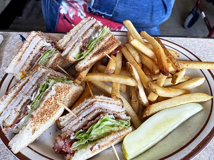 The club sandwich towers like a delicious skyscraper, held together with toothpicks and accompanied by enough fries to justify loosening your belt.
