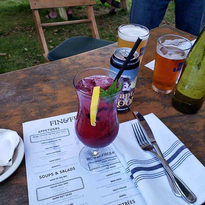 A vibrant blueberry cocktail against the backdrop of Fin & Fern's menu – Maine's famous fruit transformed into summer in a glass.
