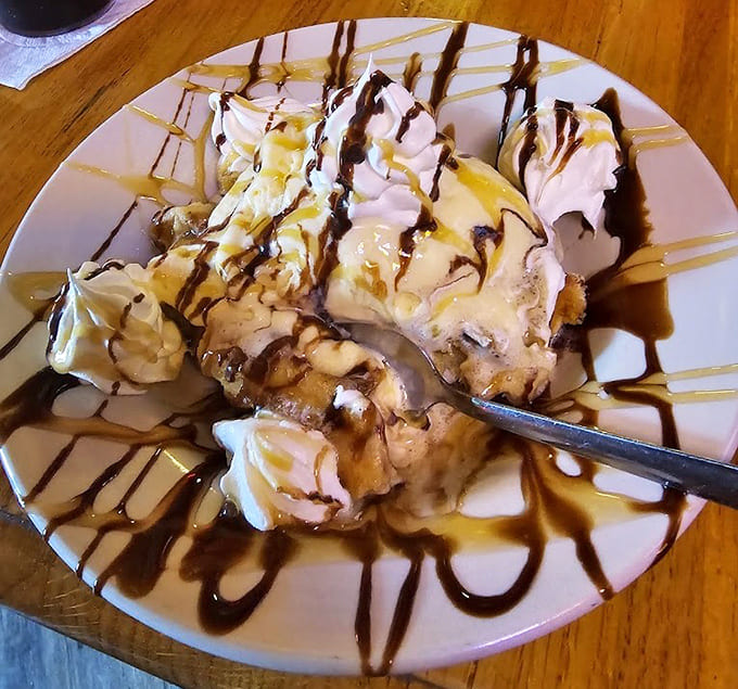 Dessert arrives as a towering monument to sweetness, drizzled with enough sauce to make your dentist nervous.