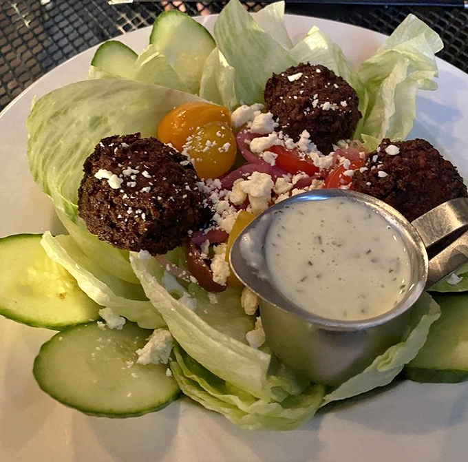 Crispy falafel spheres rest on fresh greens with feta crumbles &ndash; proof that Southern kitchens can venture beyond borders deliciously.