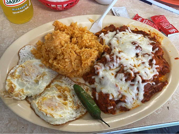 A classic Mexican plate that hits all the right notes: eggs, rice, and enchiladas swimming in rich red sauce.