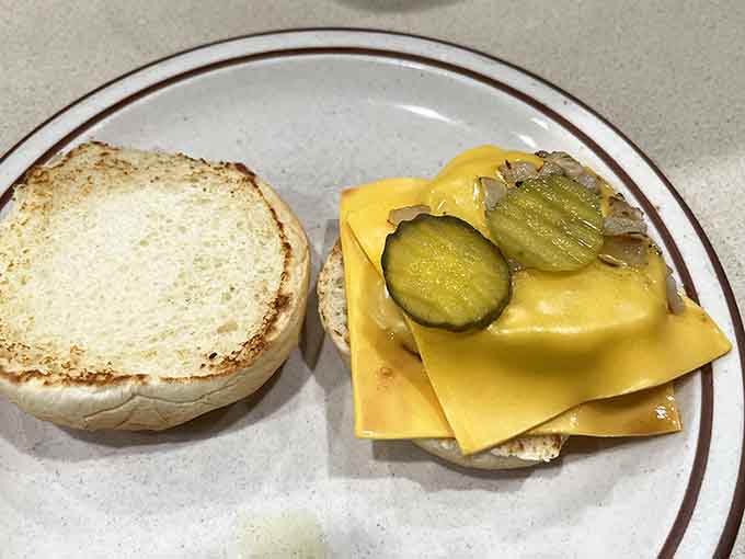 That double cheeseburger with pickles on the side is proof that Frieda's doesn't just do breakfast, they do lunch like champions too.