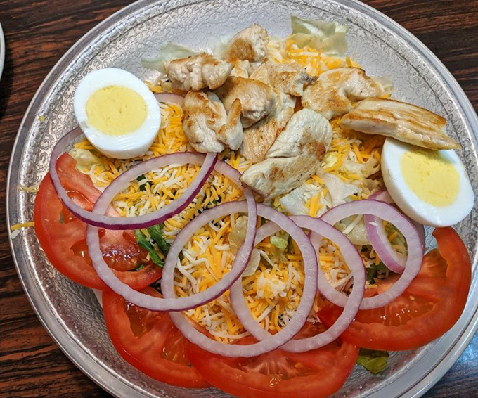 A grilled chicken salad that doesn't feel like punishment &ndash; fresh ingredients arranged with care for those seeking lighter fare.