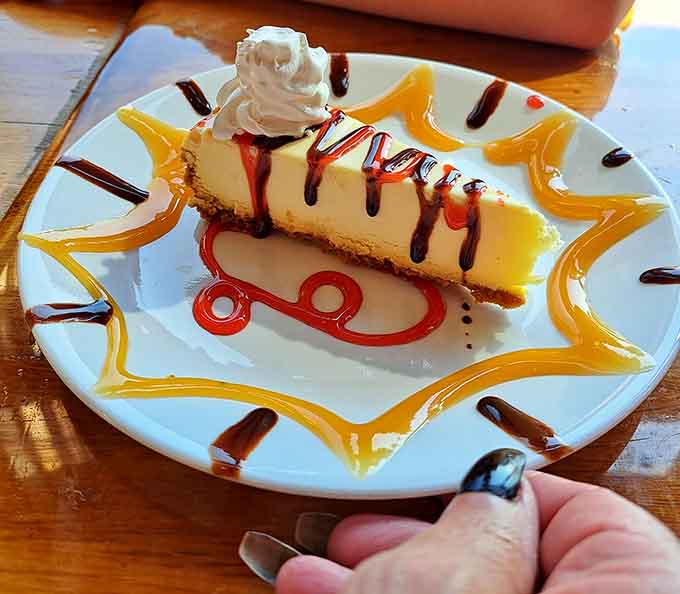 Cheesecake so creamy and decadent it deserves its own zip code, complete with artistic sauce work worthy of framing.