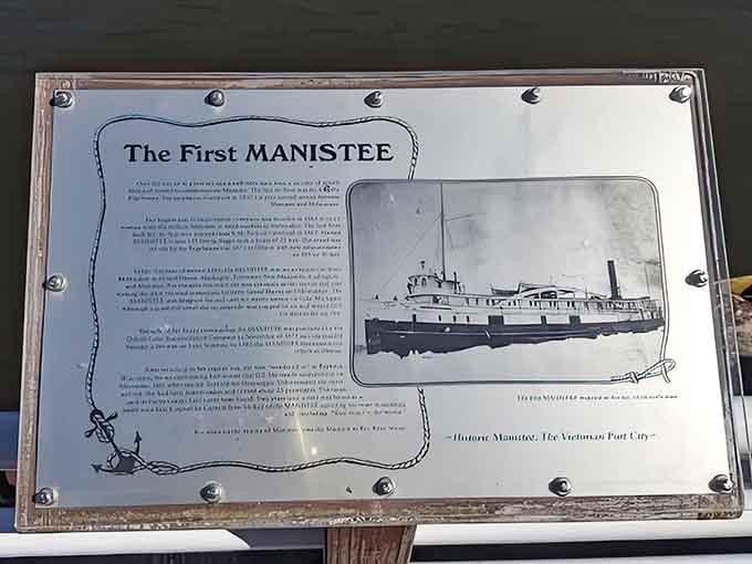 The historical marker tells tales of "The First Manistee," connecting modern-day strollers with the vessels that once plied these same waters.