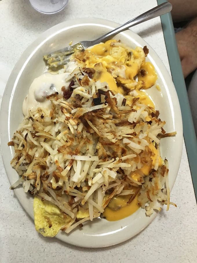 The legendary horseshoe: A monument to Midwestern ingenuity where toast, meat, and eggs disappear beneath crispy hash browns and cascading cheese sauce.