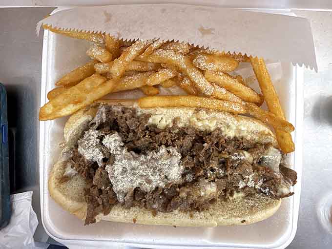 The Philly cheesesteak arrives loaded with enough meat and cheese to require both hands and possibly a detailed eating strategy.